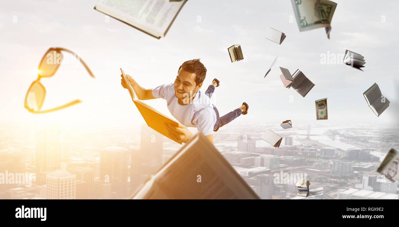 Funny guy with book in hands levitating in air. Mixed media Stock Photo ...