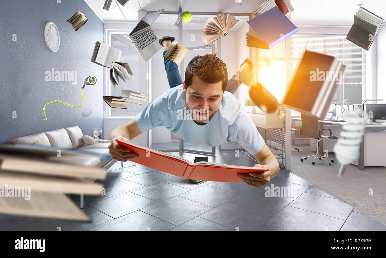 Funny guy with book in hands levitating in air. Mixed media Stock Photo ...