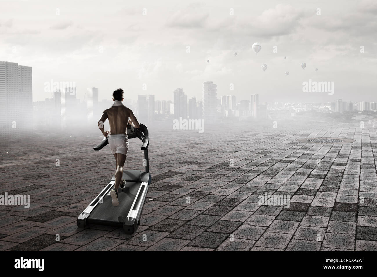 Back view of man athlete running on treadmill. Mixed media Stock Photo ...