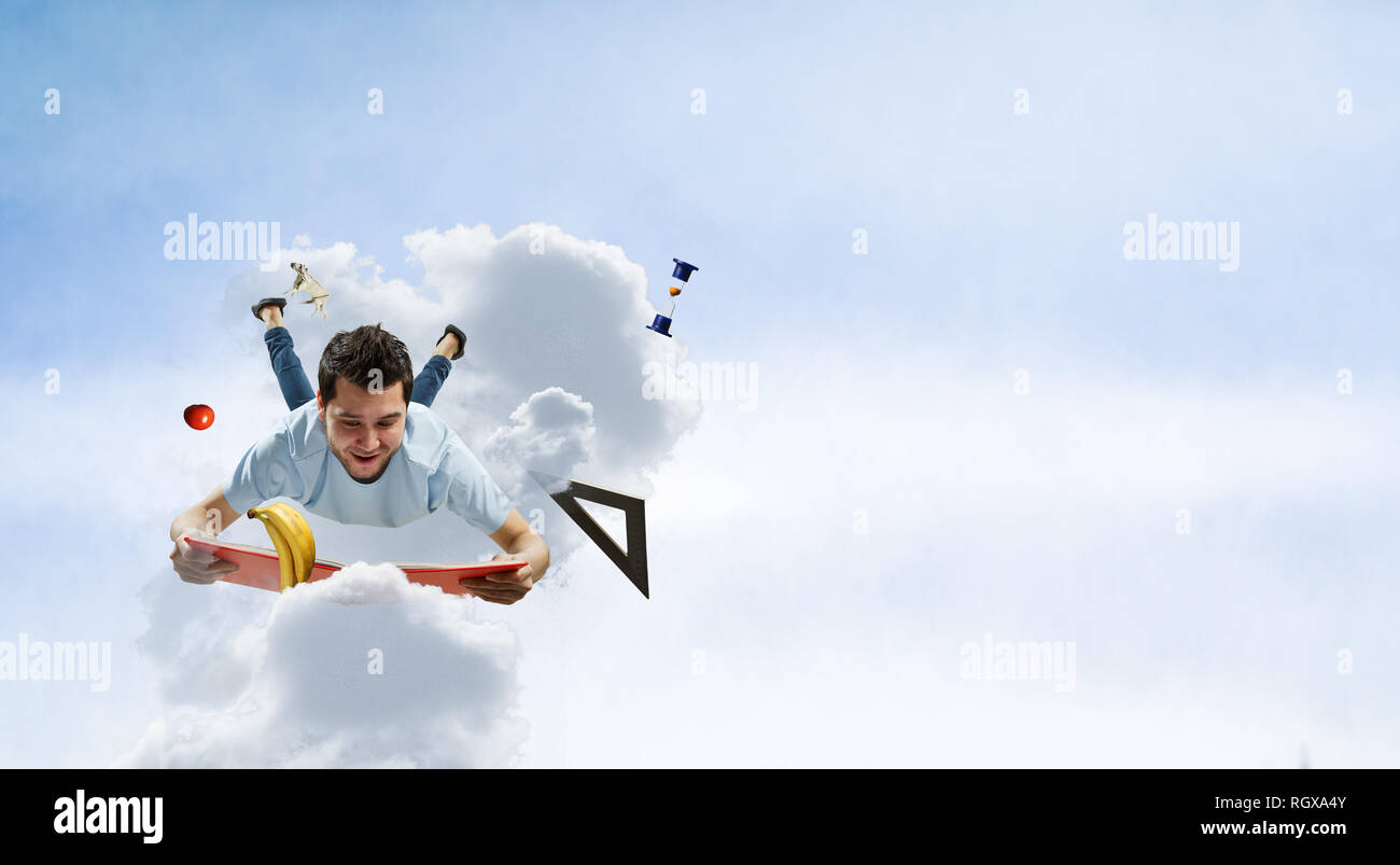 Funny guy with book in hands levitating in air. Mixed media Stock Photo ...