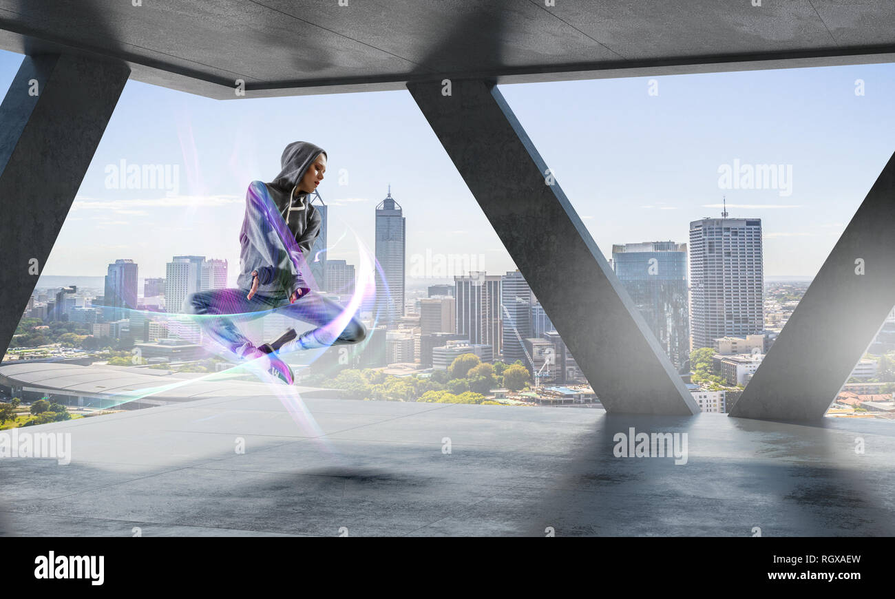Girl breakdancer performing jump in office interior. Mixed media Stock ...