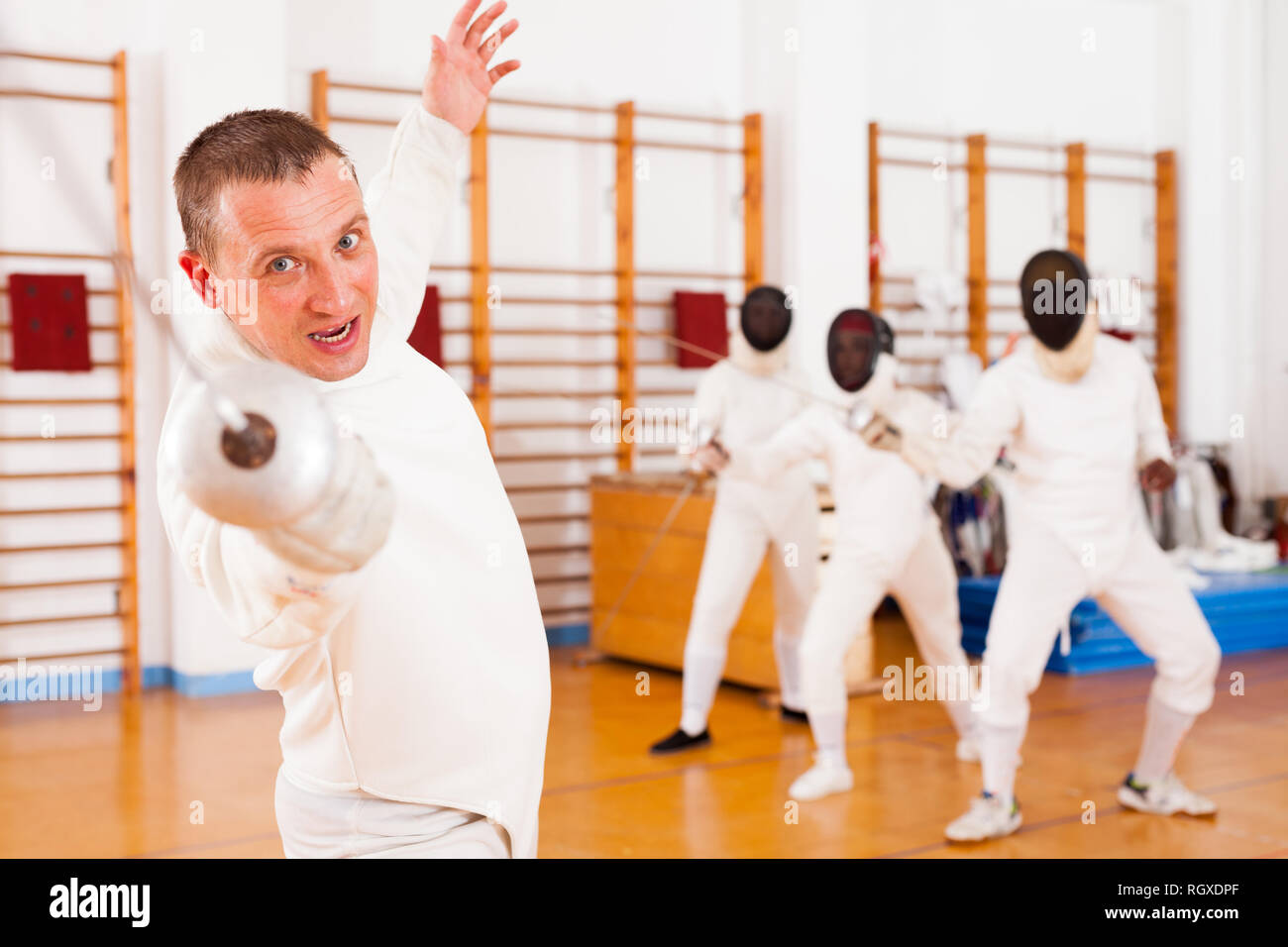 Sporty young man fencer practicing effective fencing techniques in ...