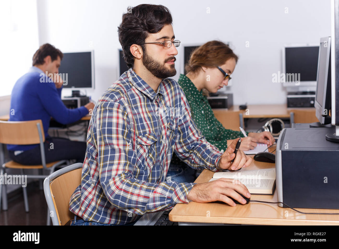Serious adult student reading textbooks while studying in university ...