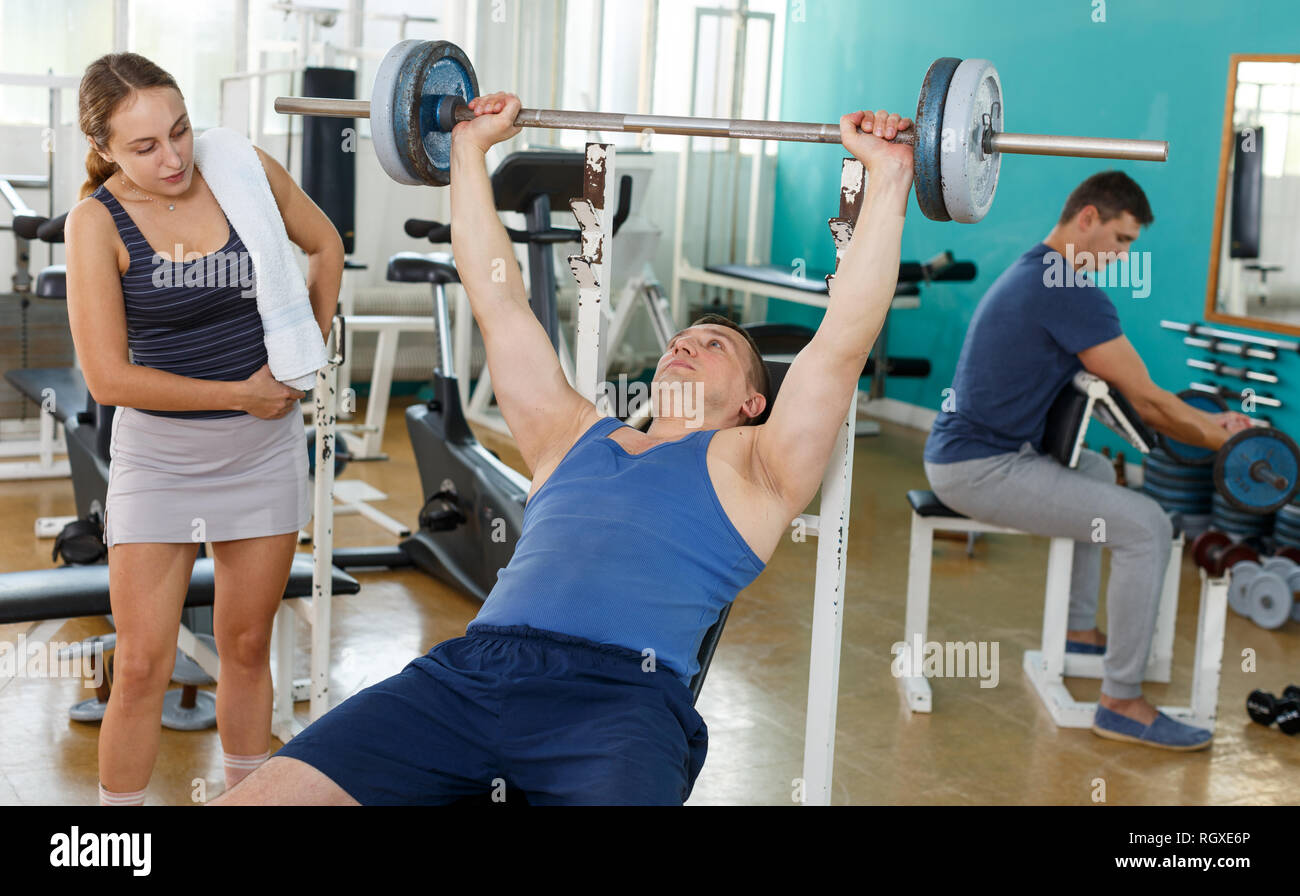 Group of people doing exercises with barbell in sport club Stock Photo ...