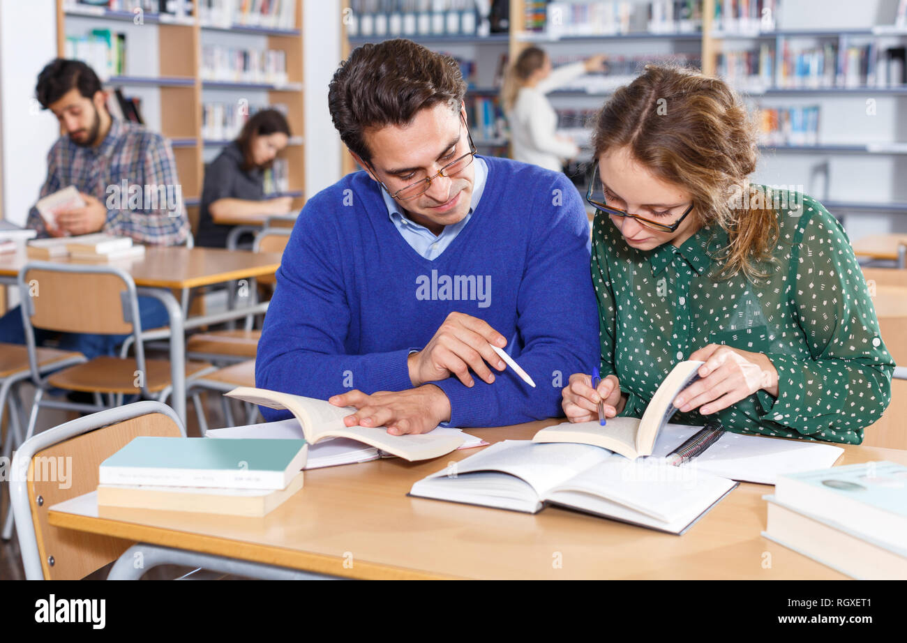 Portrait of couple of adult students studying together in public ...