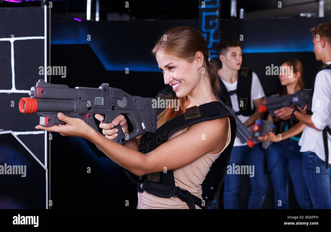 Portrait of happy young girl with laser pistol in her hands playing ...