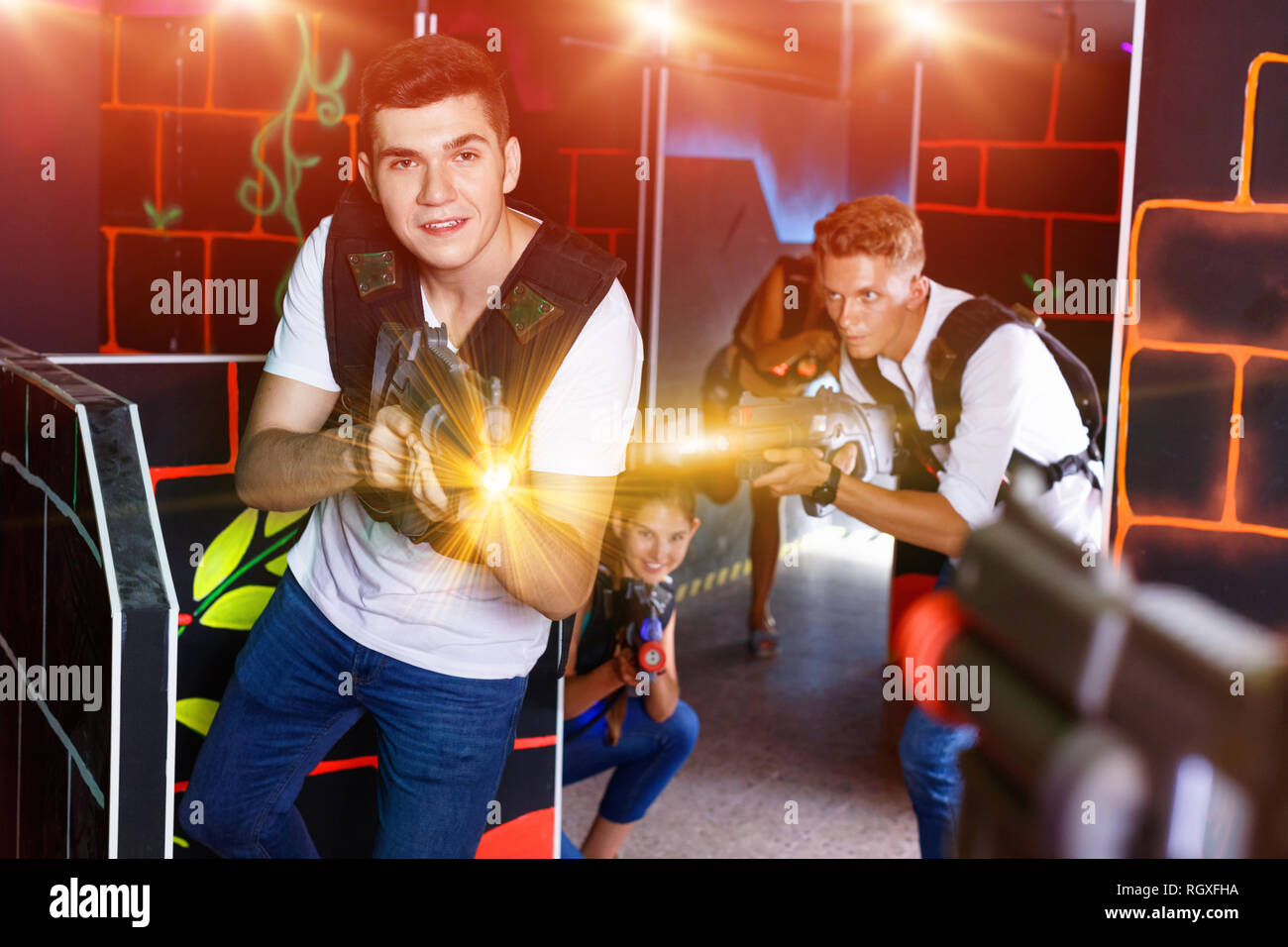 Portrait of excited happy cheerful glad guy with laser pistol playing ...