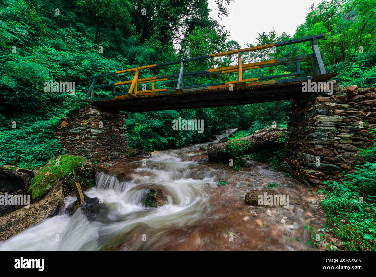 Photo of wooden bridge over waterfall in himalayas - sainj, kullu ...