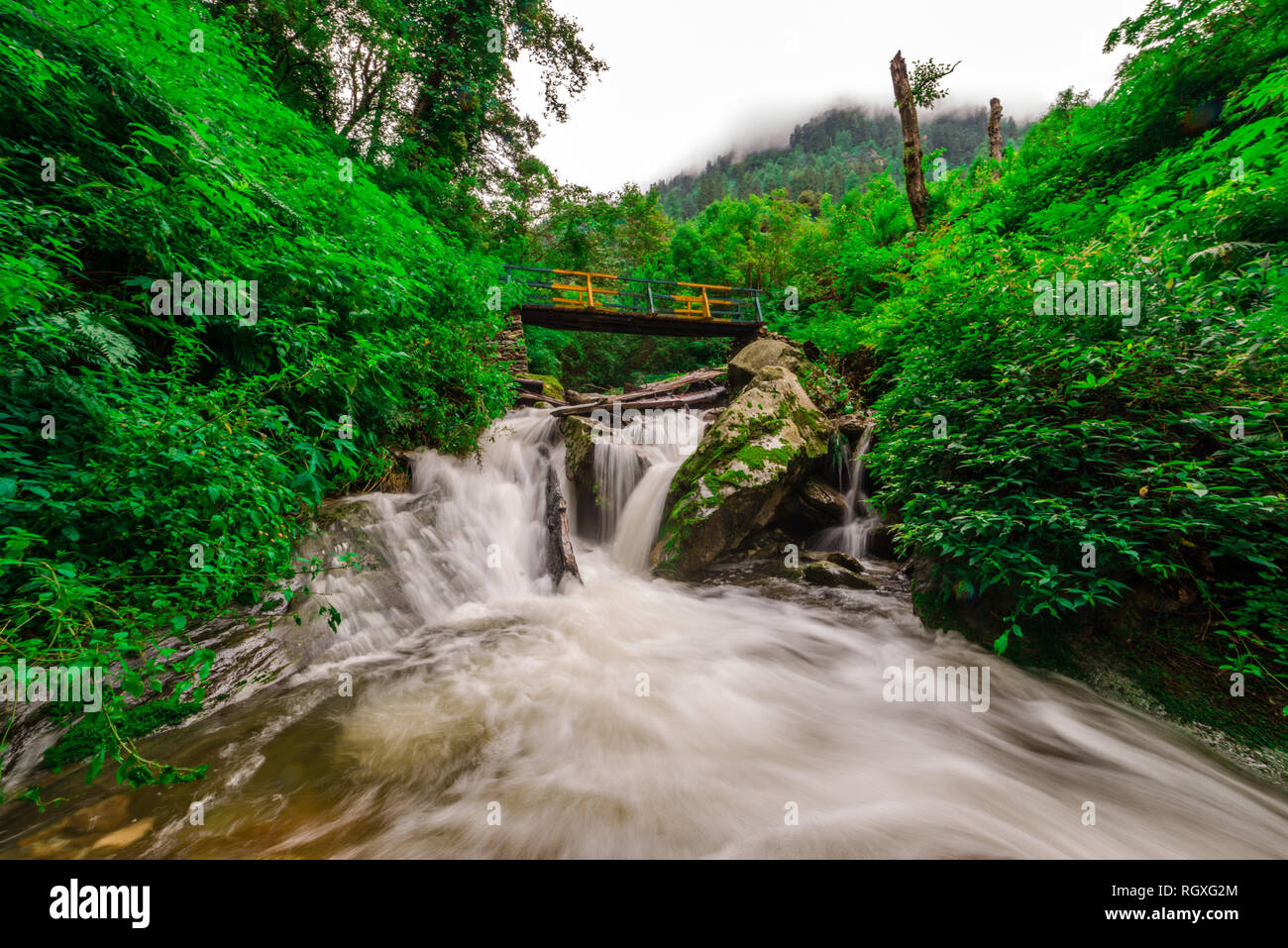 Photo of wooden bridge over waterfall in himalayas - sainj, kullu ...