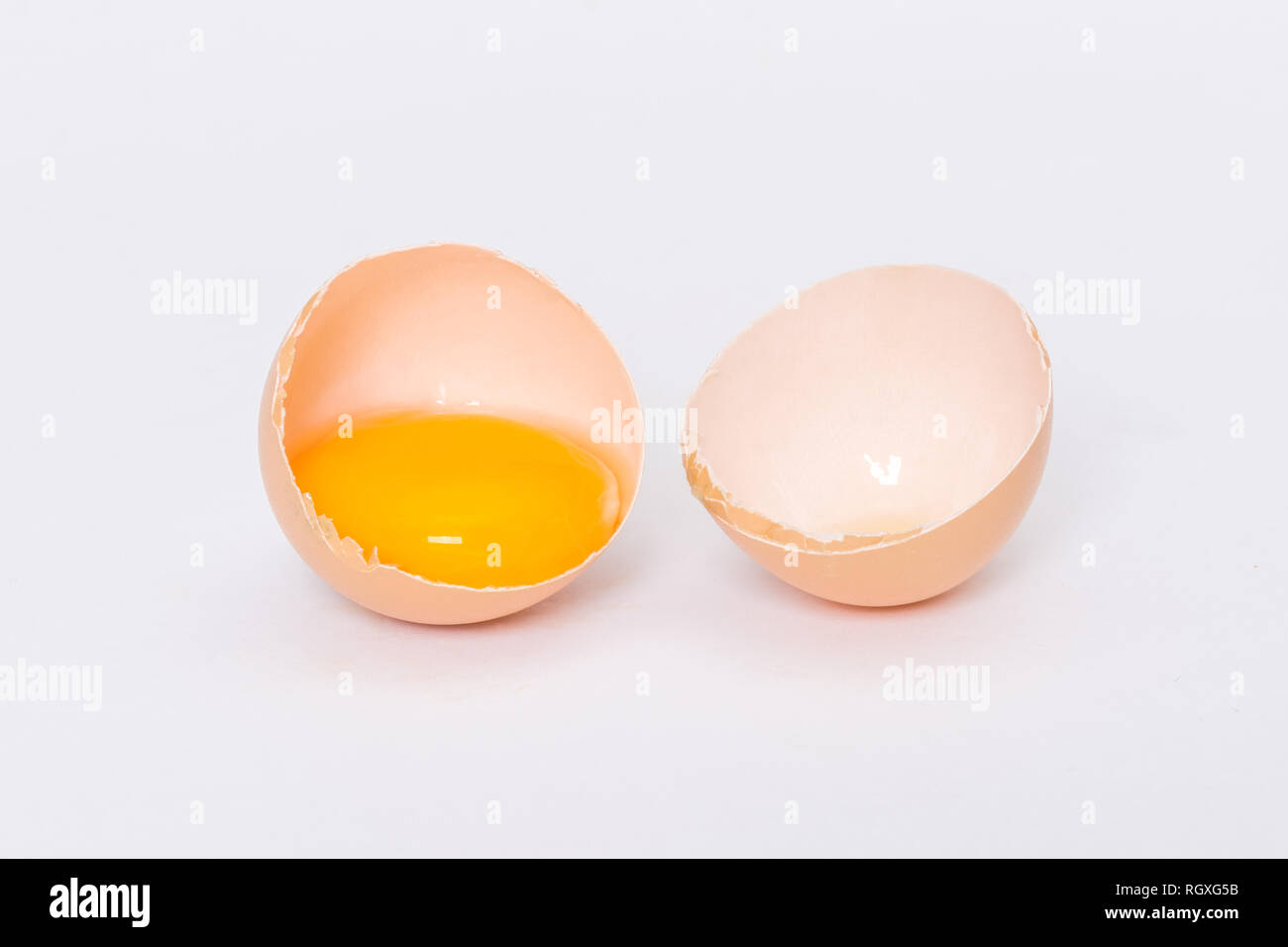 Broken egg on a white background Stock Photo - Alamy