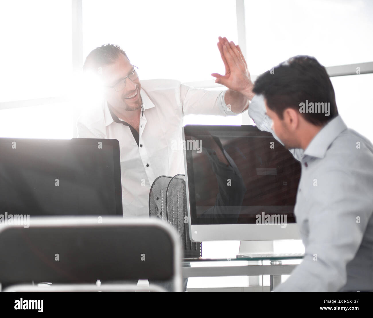 employees give each other a high five over the computer Desk Stock ...