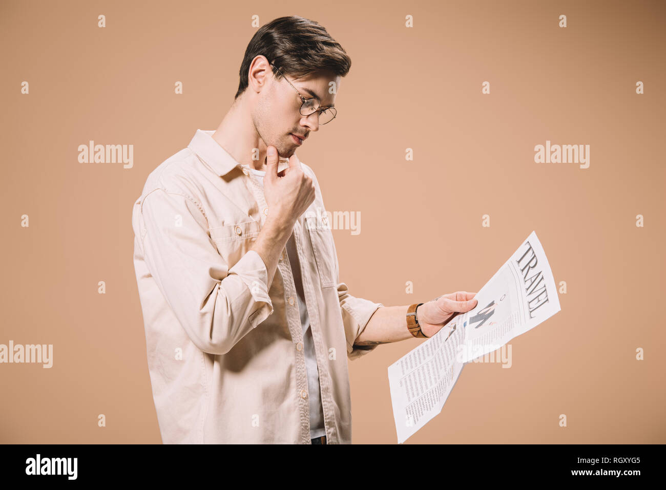 thoughtful man reading travel newspaper isolated on beige Stock Photo ...
