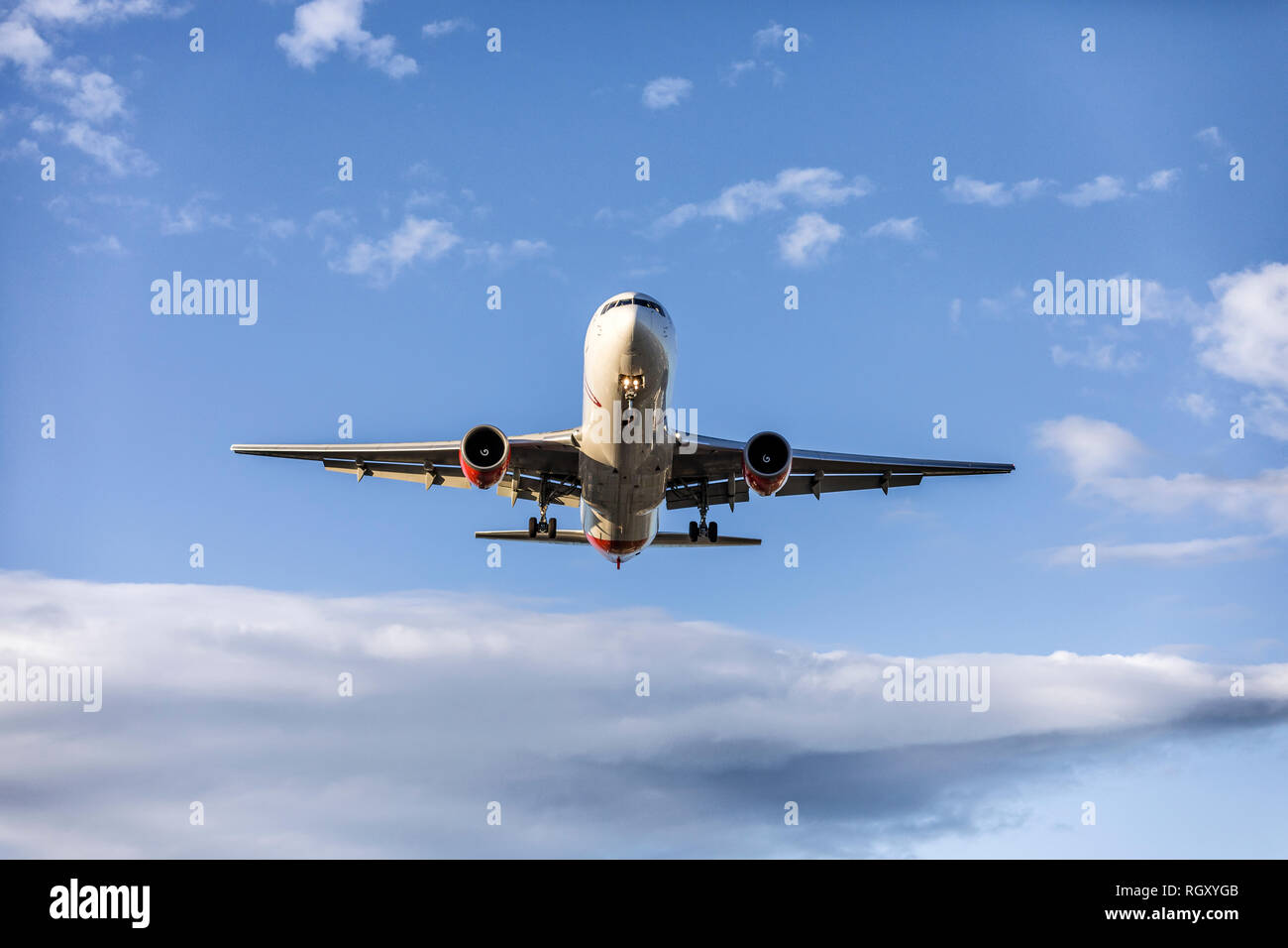 Flying passenger airplane preparing to land Stock Photo - Alamy