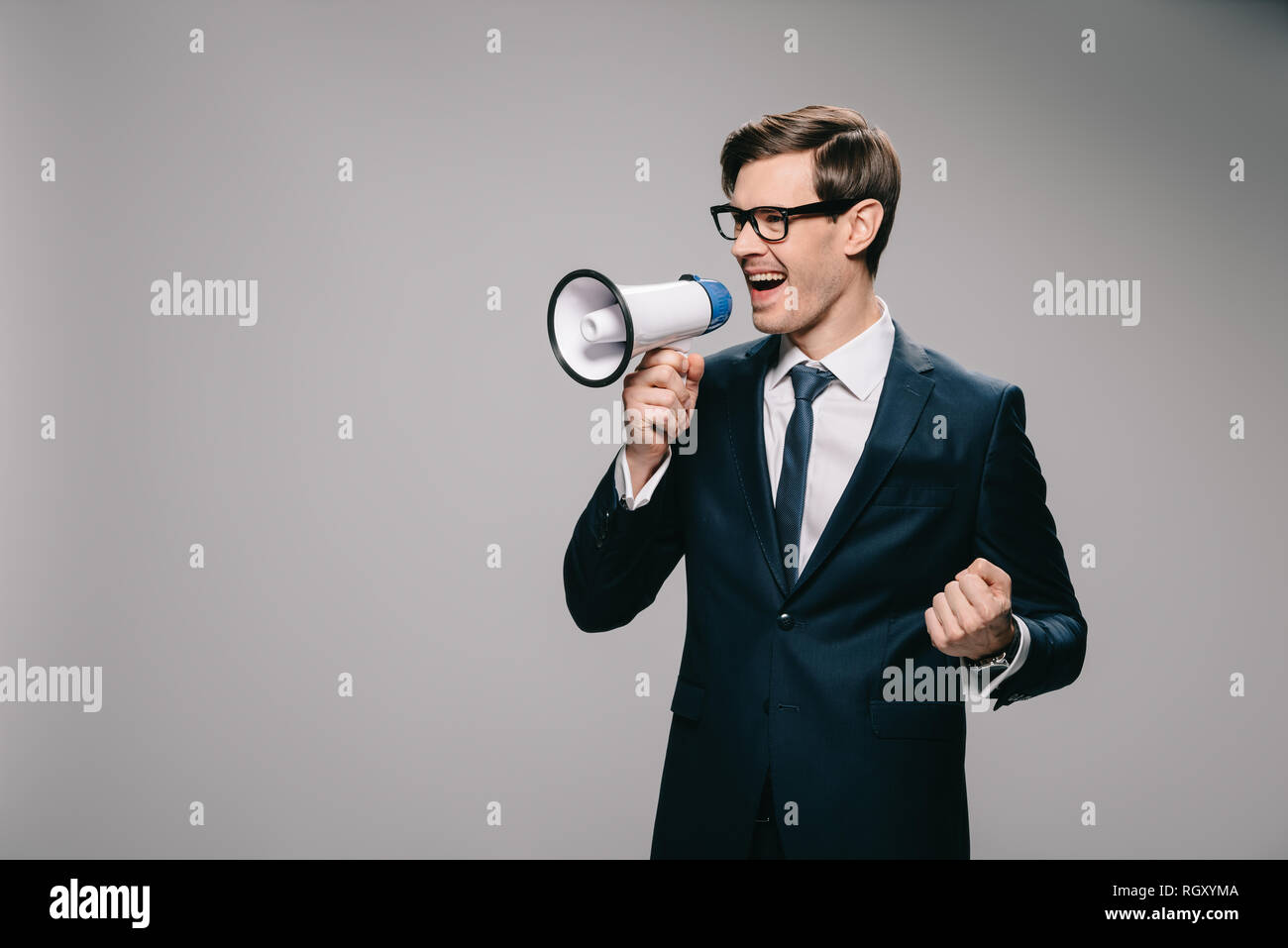 happy businessman screaming in megaphone on grey background Stock Photo ...