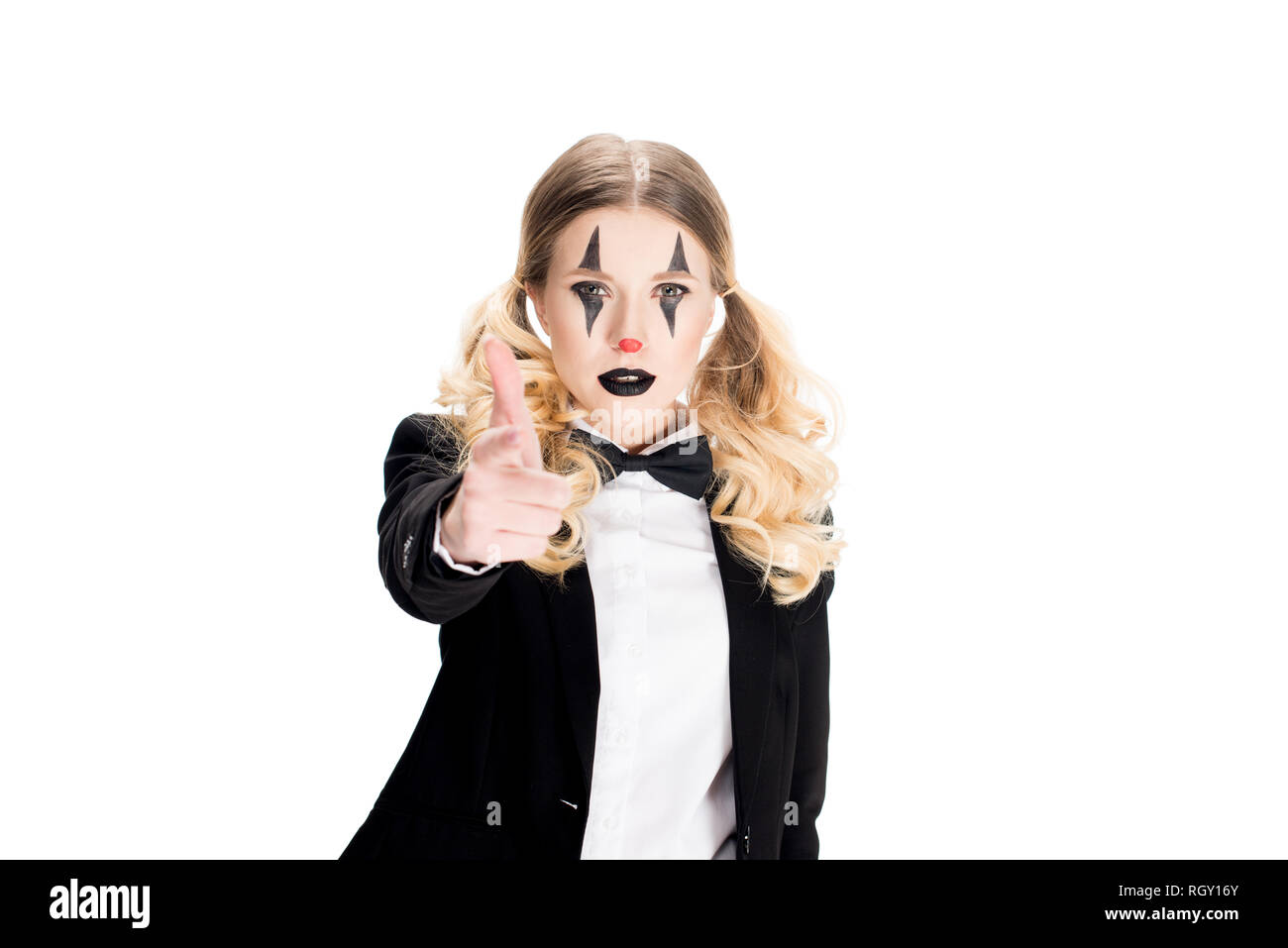 serious female clown in suit looking at camera and pointing with finger ...