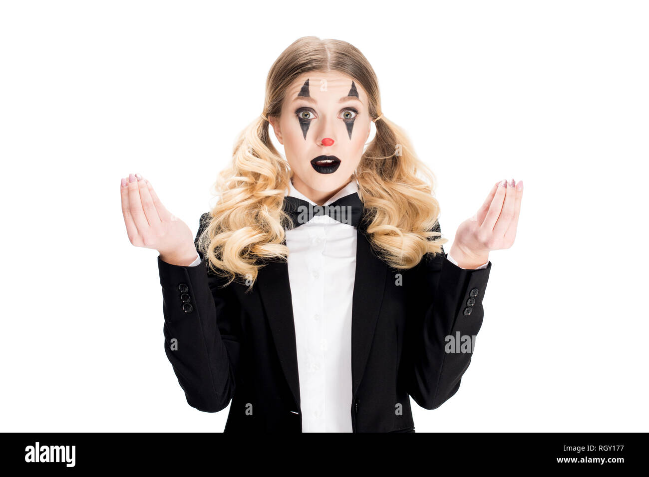 surprised female clown standing in suit and gesturing isolated on white ...