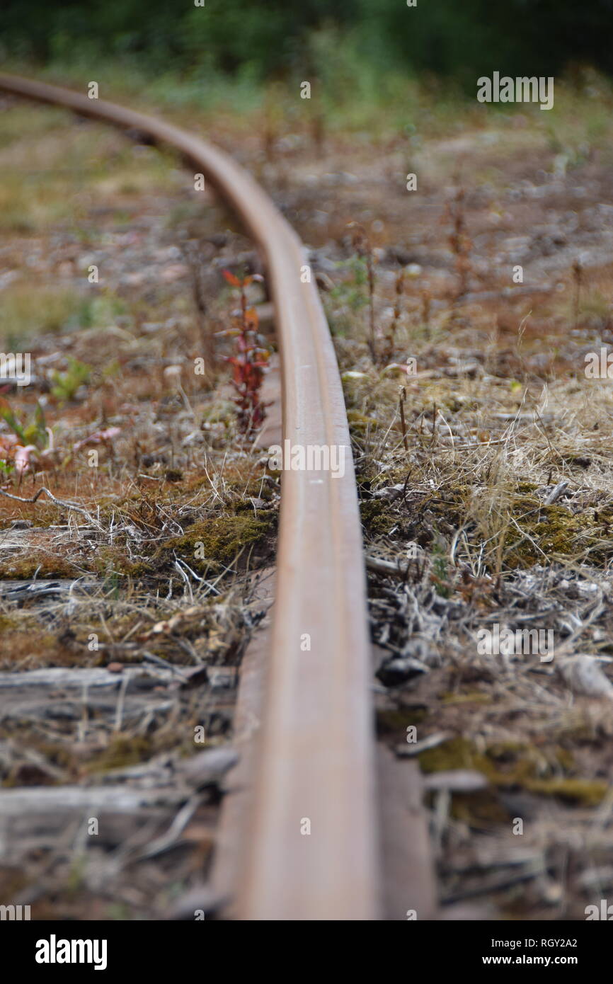 Single railway track curving in to the distance Stock Photo - Alamy