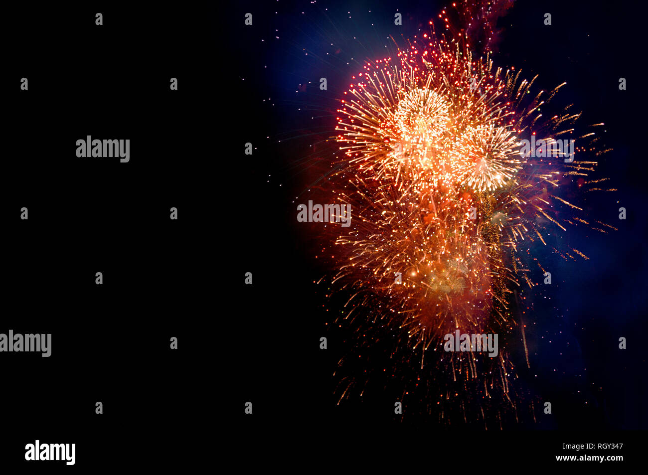 Red, orange, and yellow fireworks display on black background with room ...