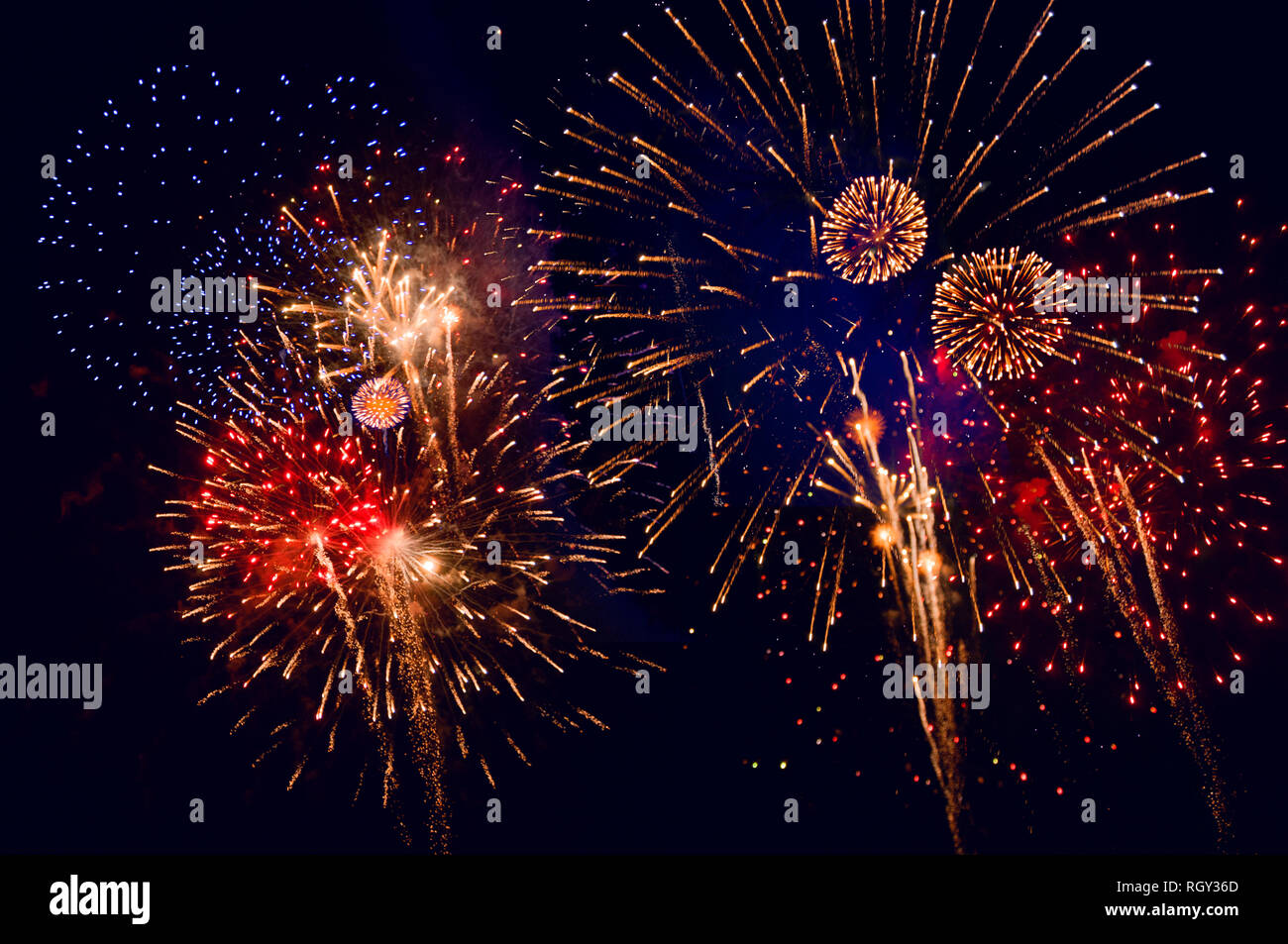Red, orange, blue and yellow fireworks display on black background ...