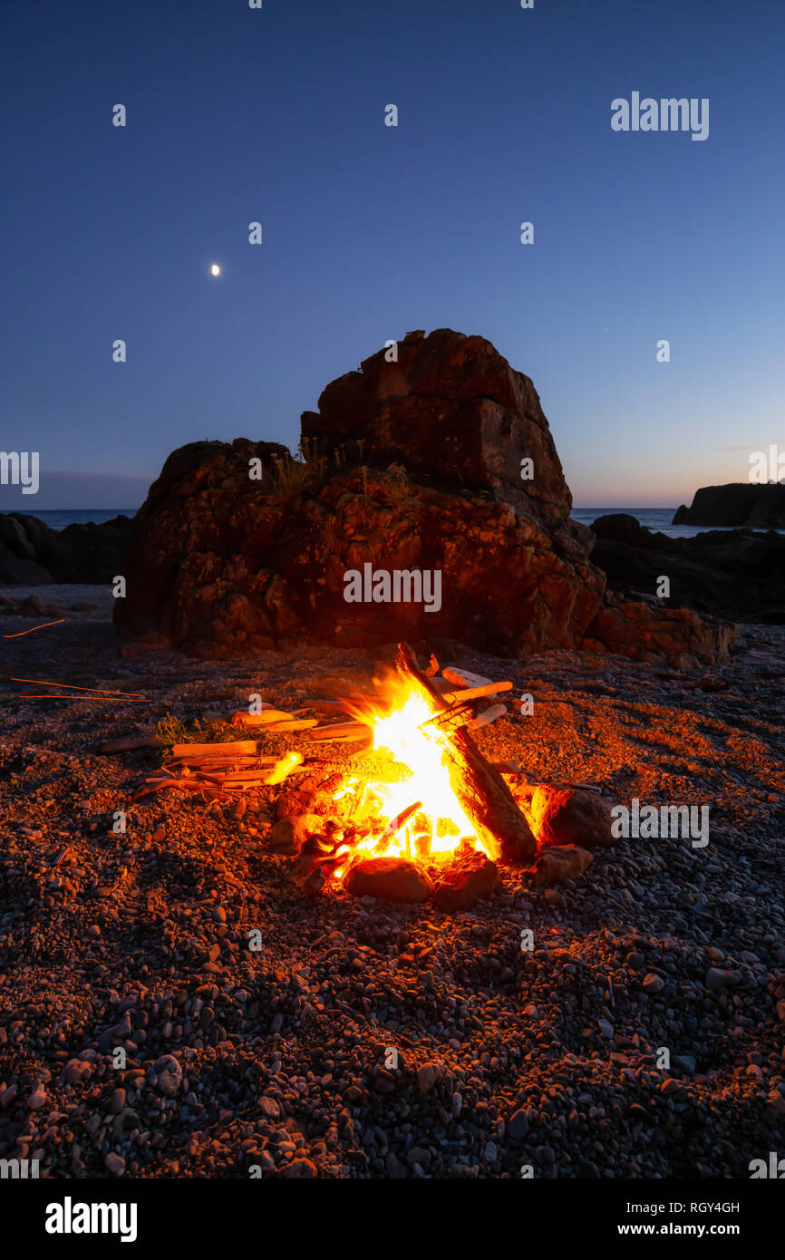 Camp fire on the beach during a vibrant summer sunset. Taken in ...