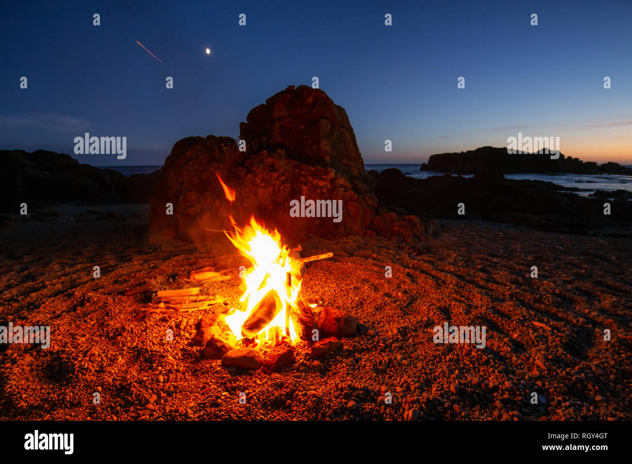 Camp fire on the beach during a vibrant summer sunset. Taken in ...
