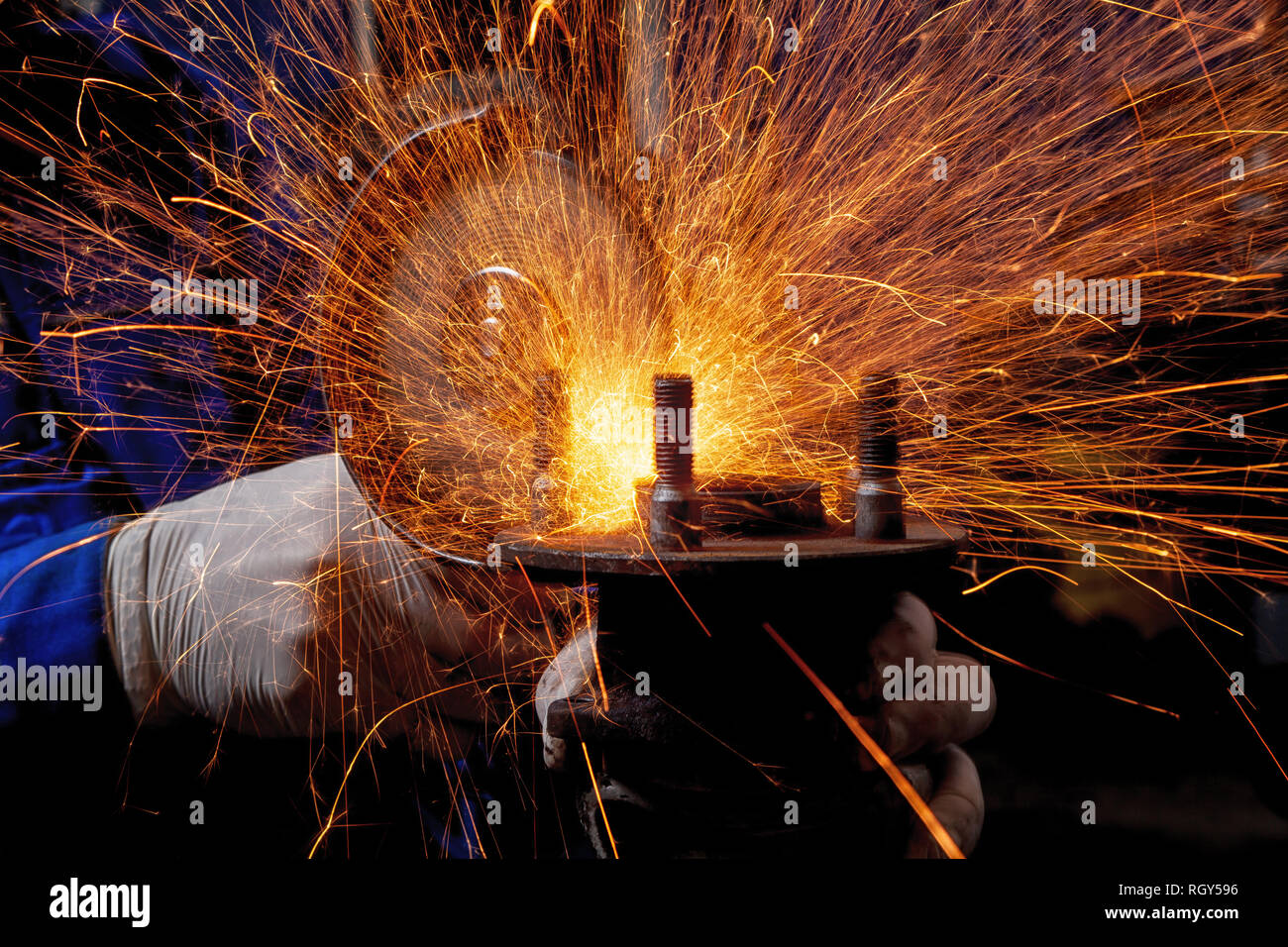 A close-up of cutting a metal car part with a angle grinder machine on ...