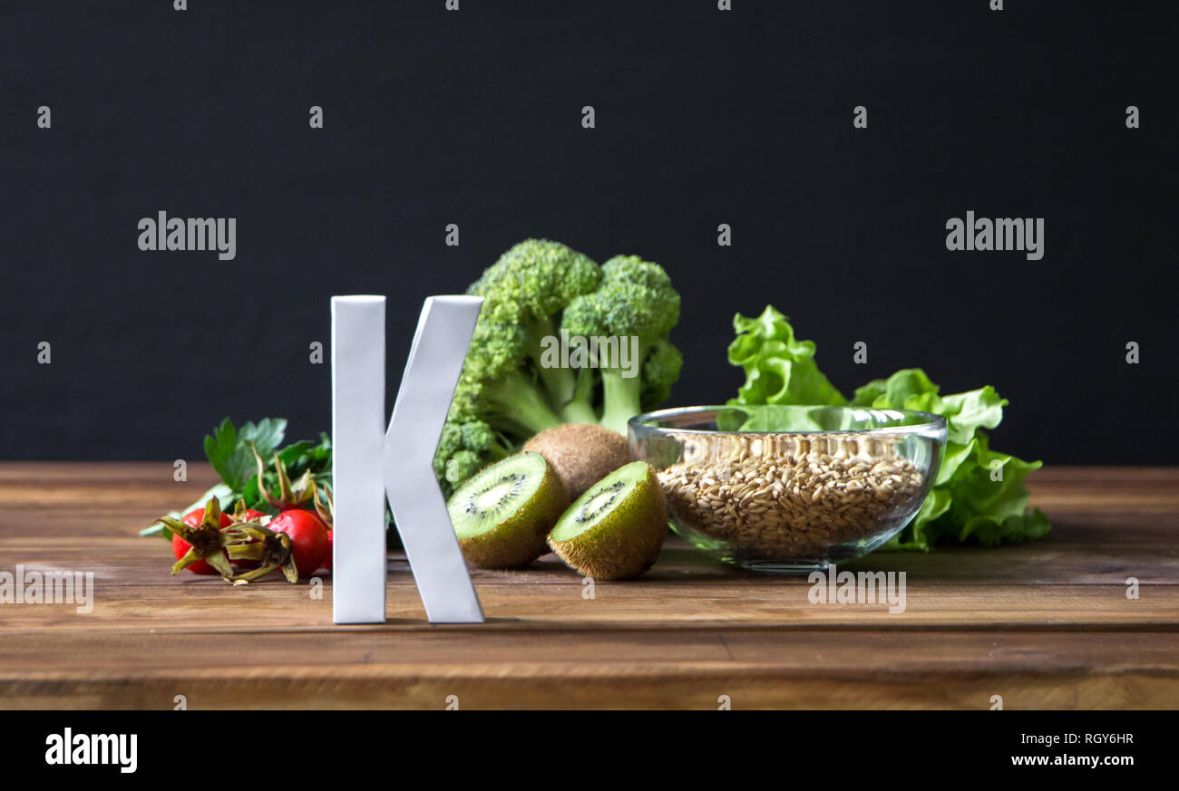 Foods highest in Vitamin K and letter K on a wooden board. Healthy ...