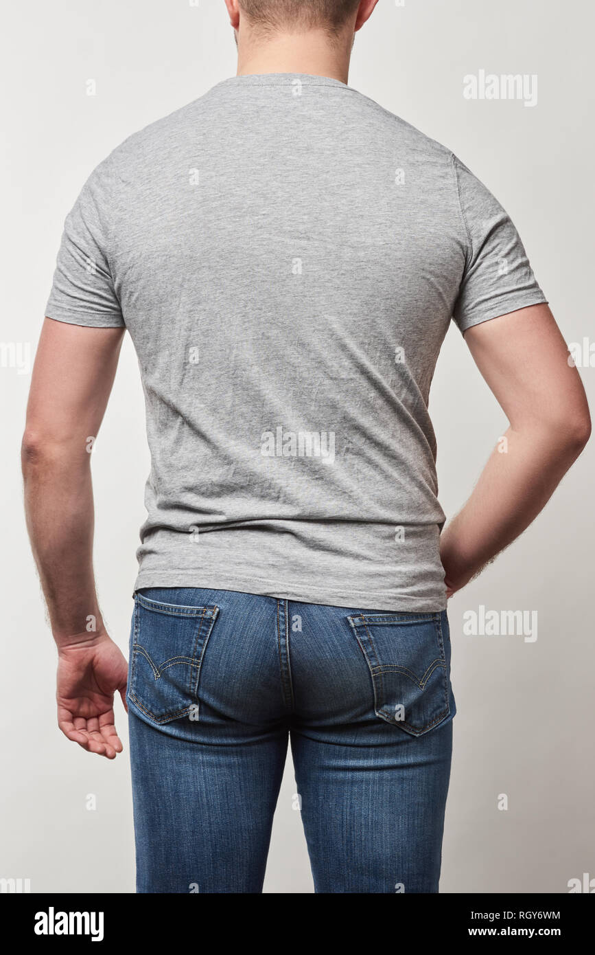 back view of man in denim and t-shirt with copy space isolated on grey ...