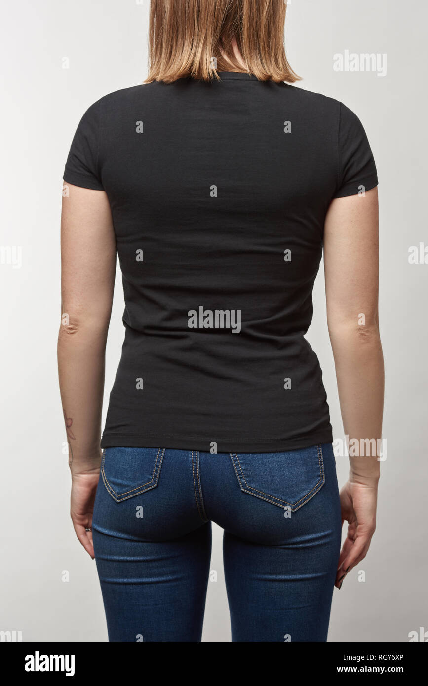 back view of young woman in black t-shirt with copy space isolated on ...
