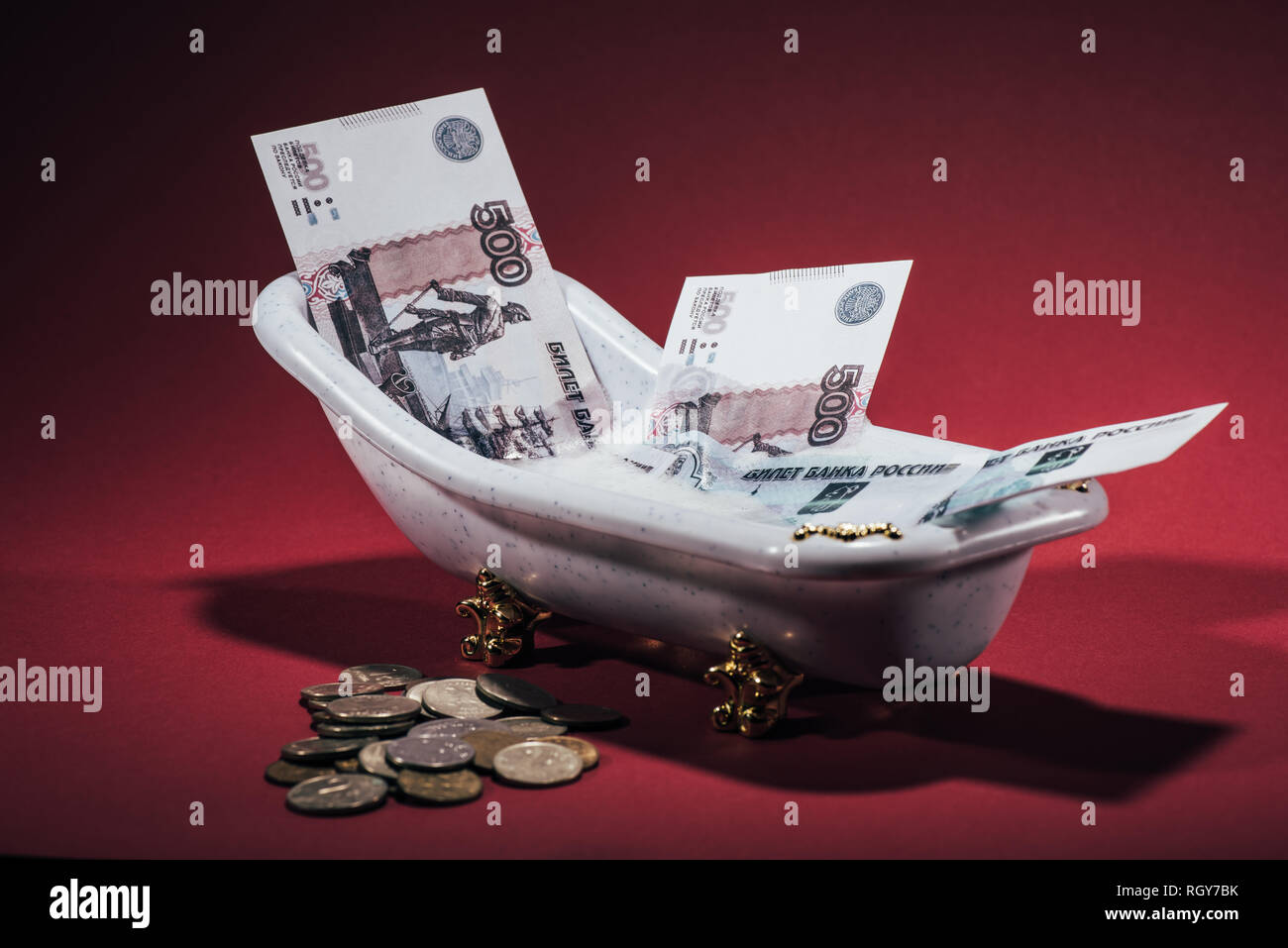 russian rubles banknotes in small tub and coins on red, money ...