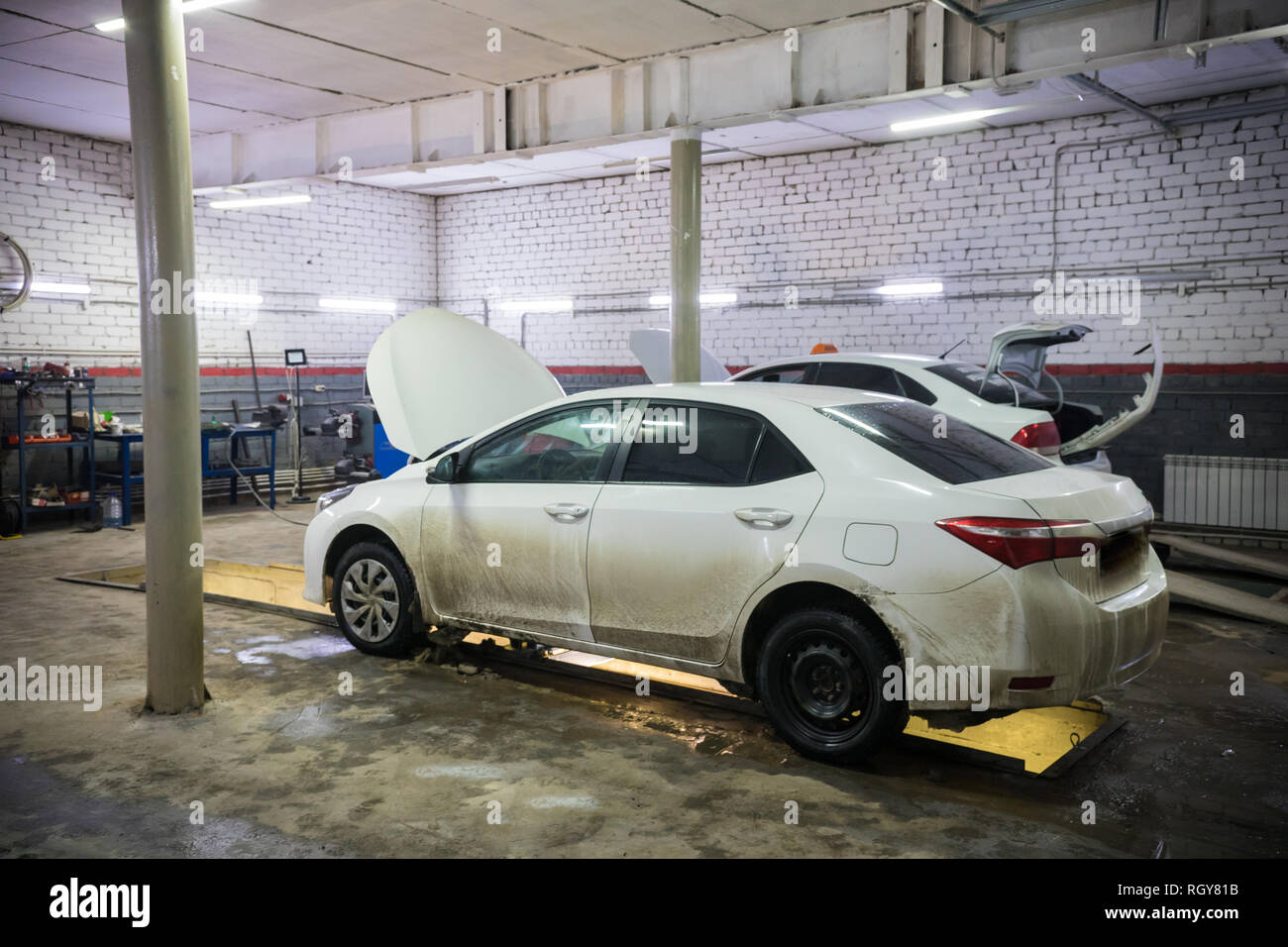 Car repair service. A car with an opened hood above the inspection pit ...