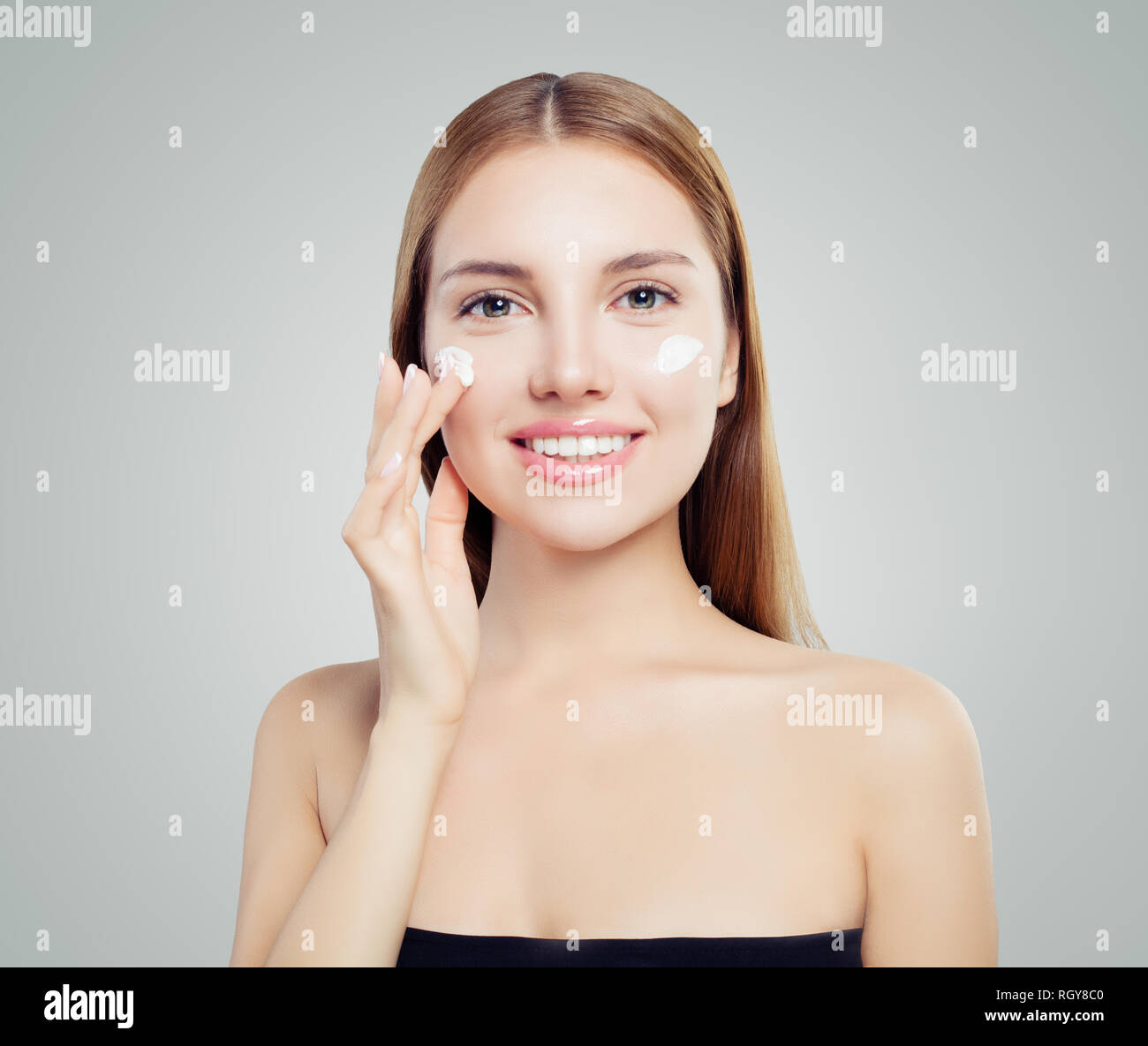 Happy beautiful woman putting cream on healthy skin. Pretty girl with ...