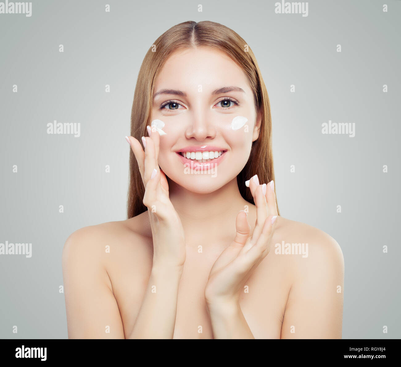 Young woman applying cream on healthy skin, spa portrait Stock Photo ...