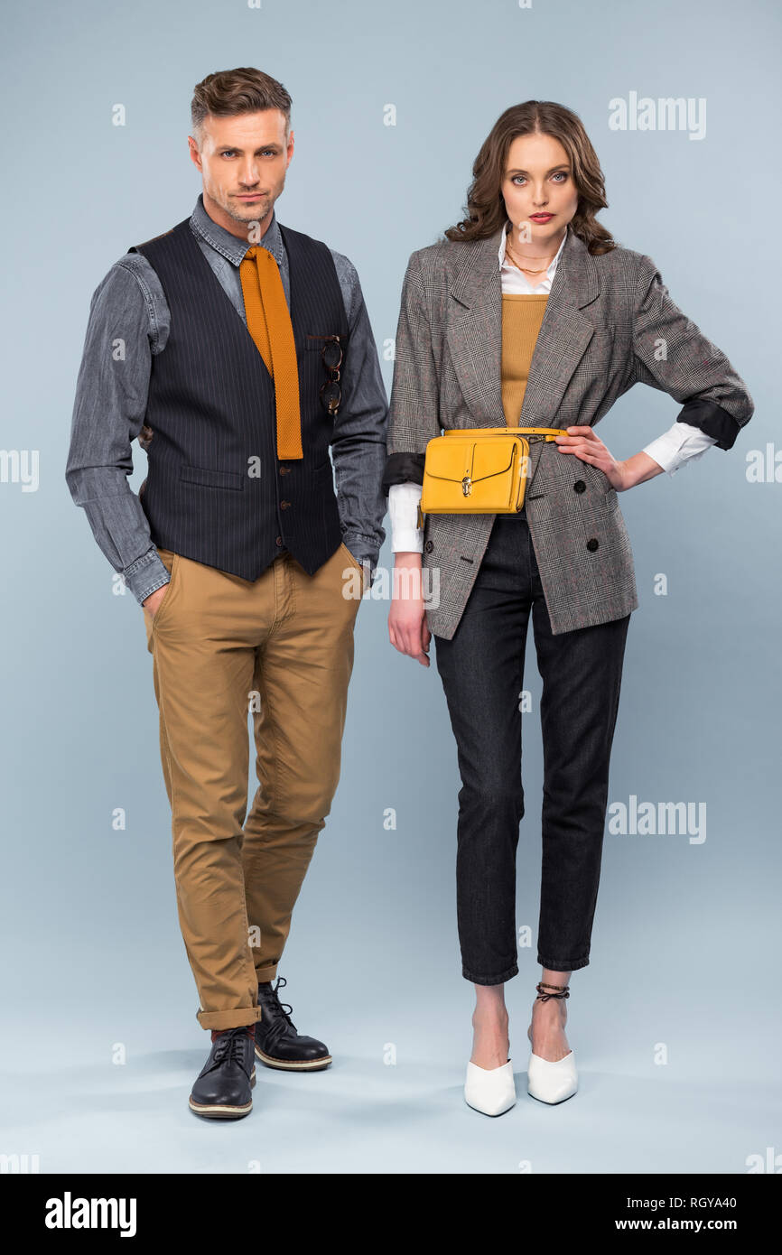 beautiful stylish couple in formal wear looking at camera while posing ...