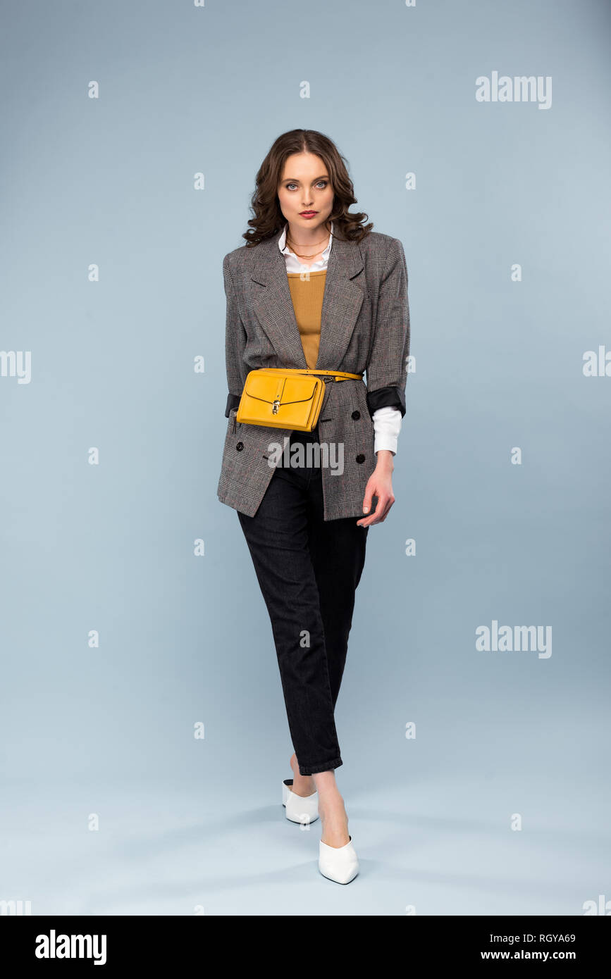 beautiful stylish woman in formal wear looking at camera and posing on ...