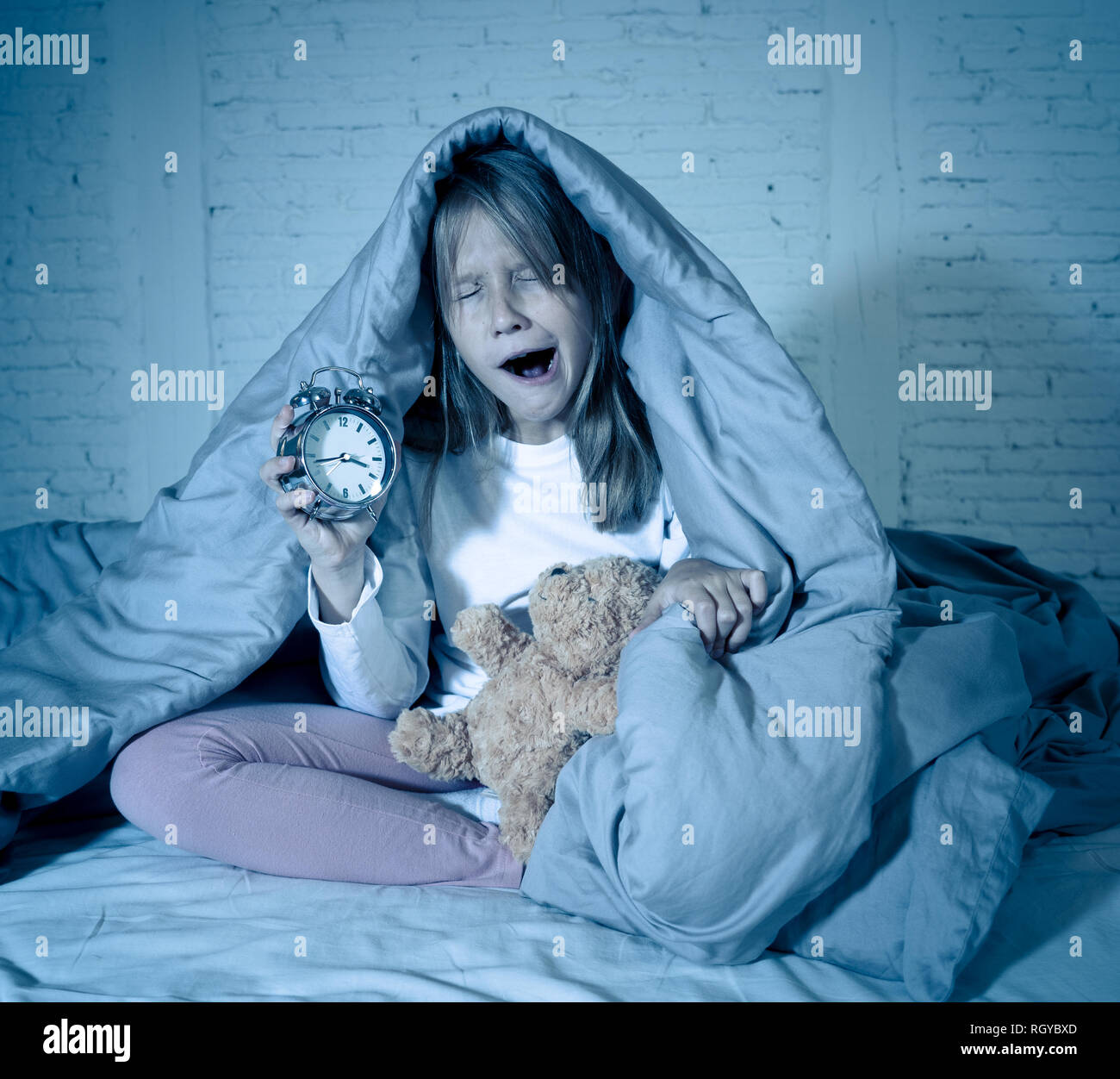 Cute sleepless little girl sitting on bed looking sad and tired having ...