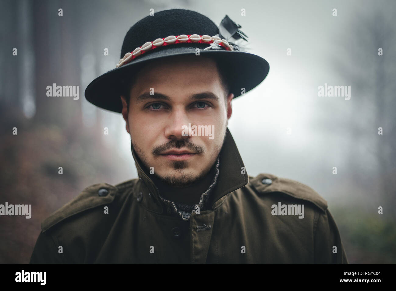 Portrait of male model with hat and beautiful eyes in deep forest at ...