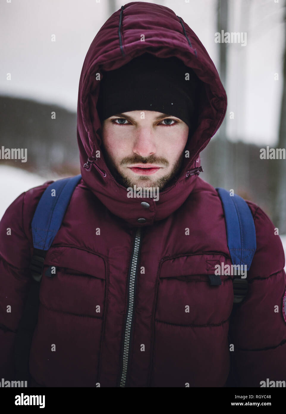 Portrait of a mountaineer man with backpack in snow blizzard. Close up ...