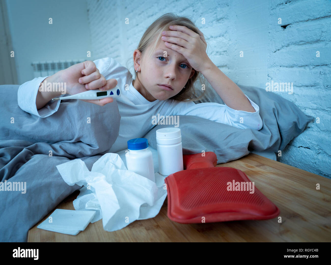 Cute sick girl in pain with high fever and headache feeling ill lying ...