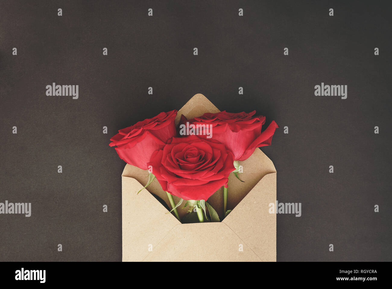 Red roses popping out of envelope in dark background. Romantic ...