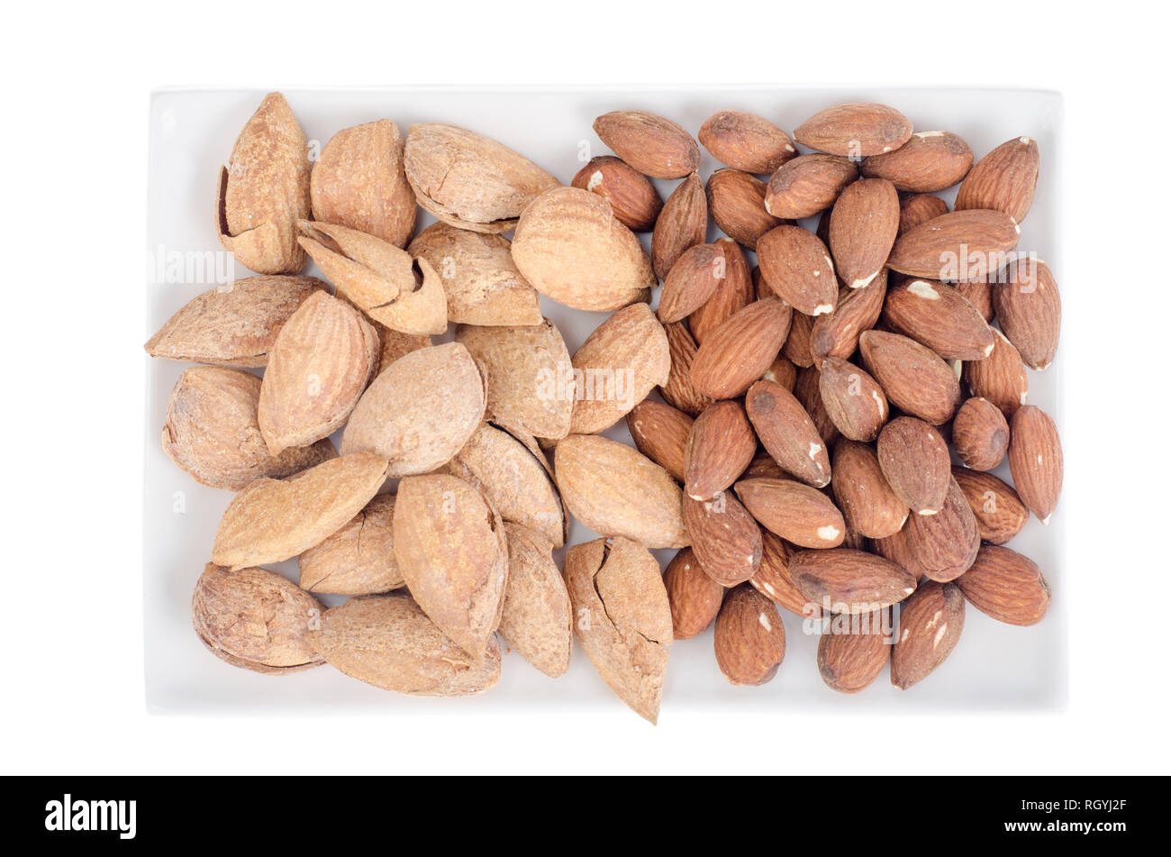 Dried peeled and unpeeled whole almonds on white plate. Studio Photo ...