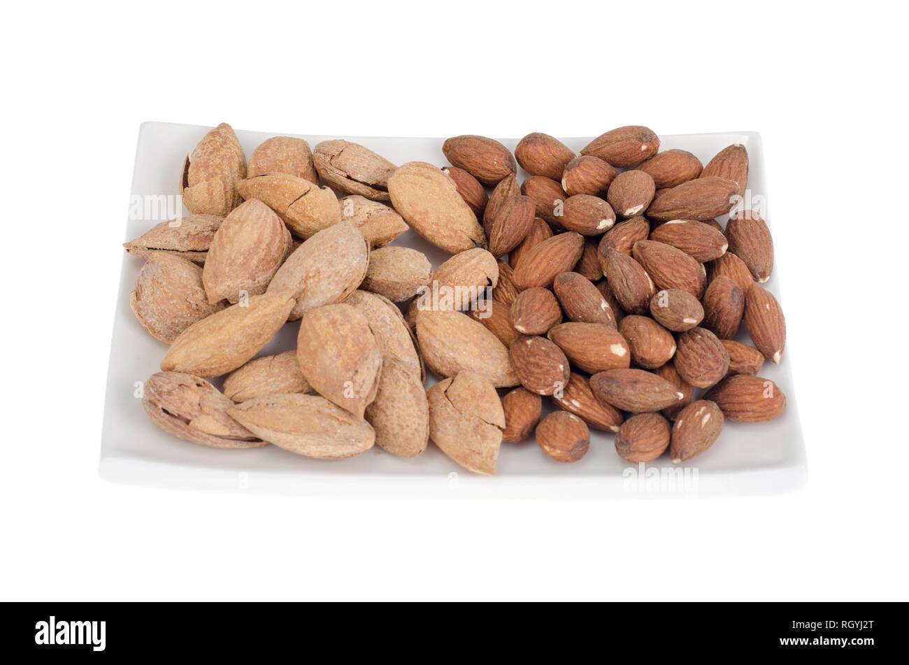 Dried peeled and unpeeled whole almonds on white plate. Studio Photo ...