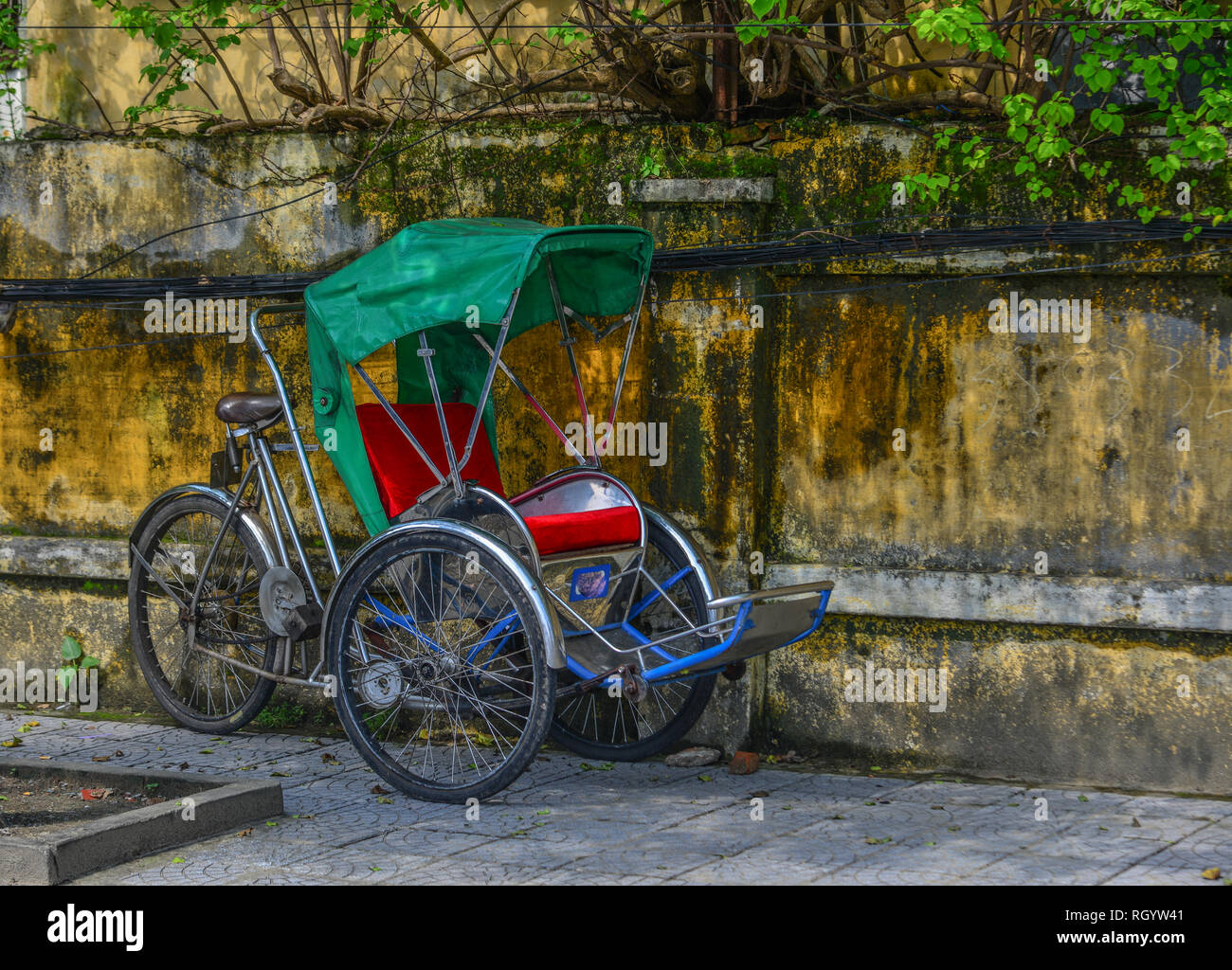 Cyclo (rickshaw) on street in Hoi An, Vietnam. Hoi An is one of popular ...