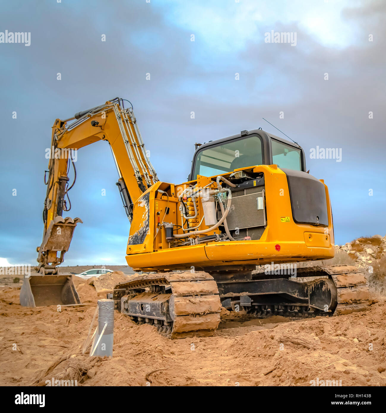 Excavator on top of dirt with cloudy sky overhead Stock Photo - Alamy