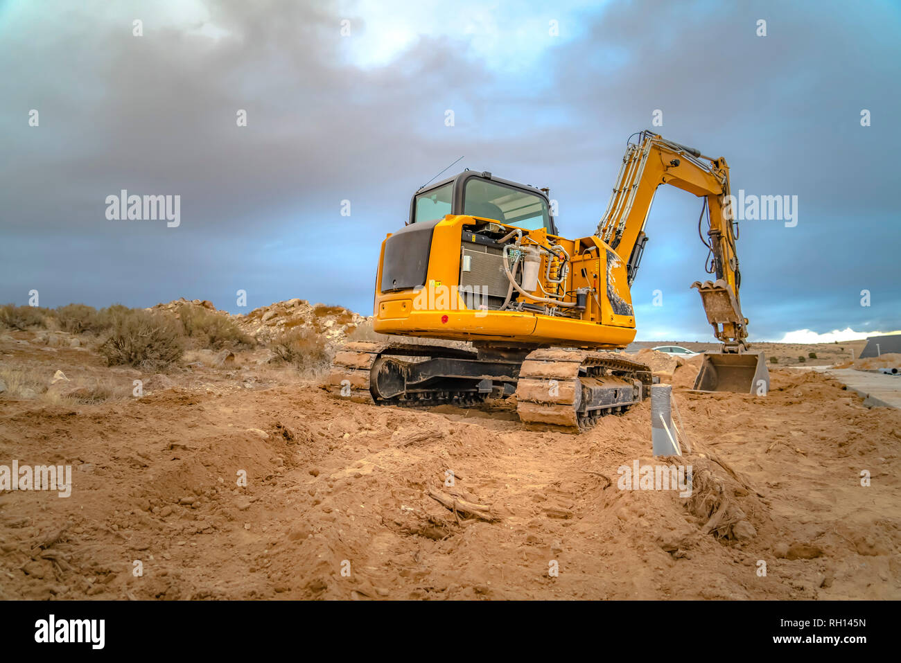 Excavator scooping and leaving tread marks on dirt Stock Photo - Alamy