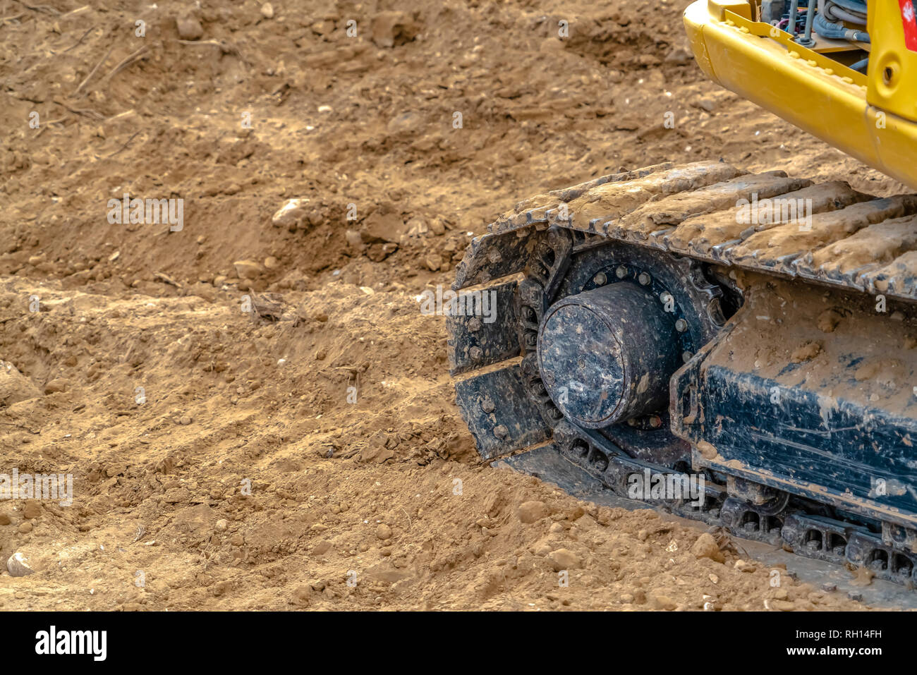 Excavator with caked dirt on its track pad in Utah Stock Photo - Alamy