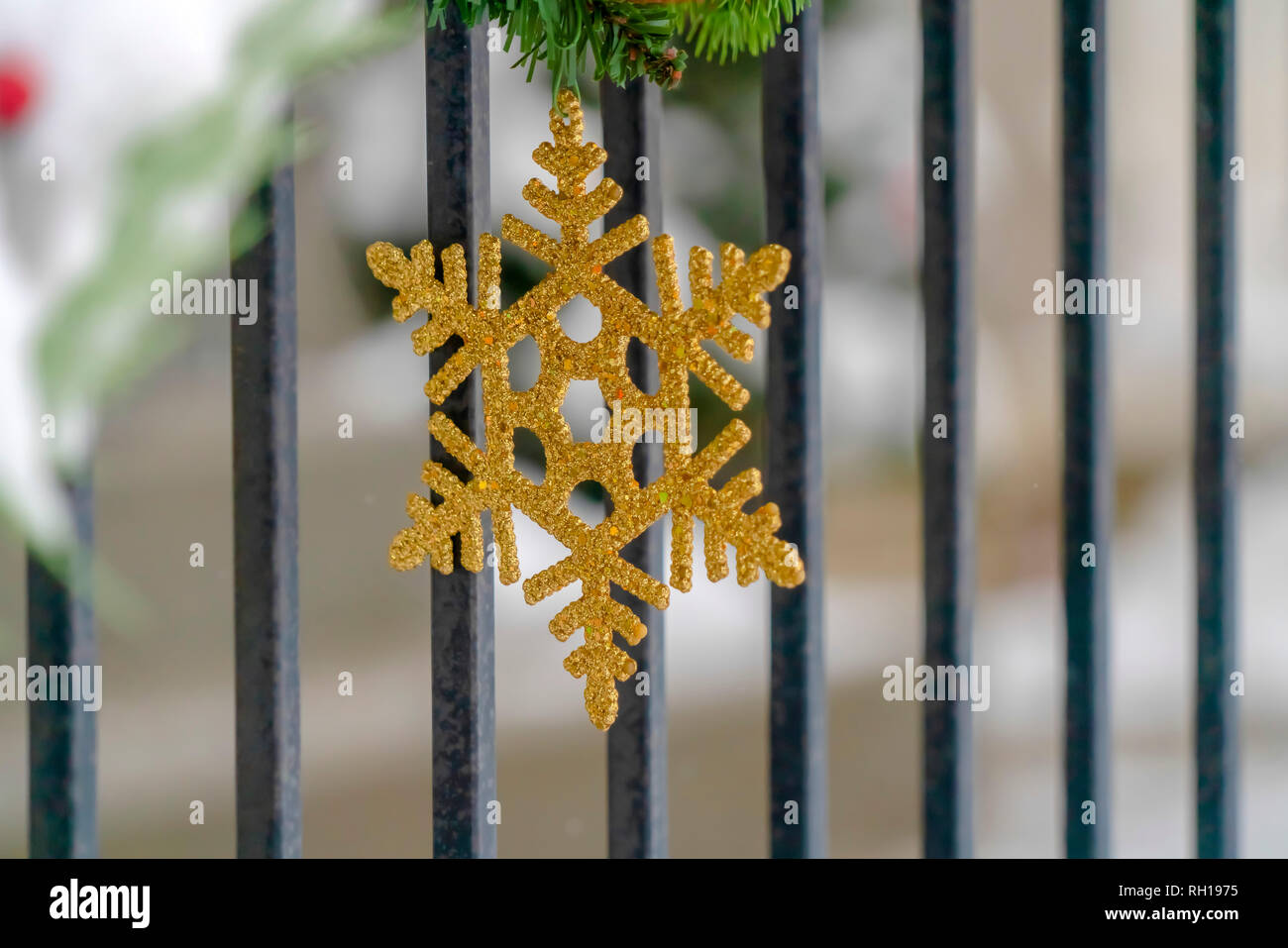 Golden snowflake on garland against dark railing Stock Photo - Alamy
