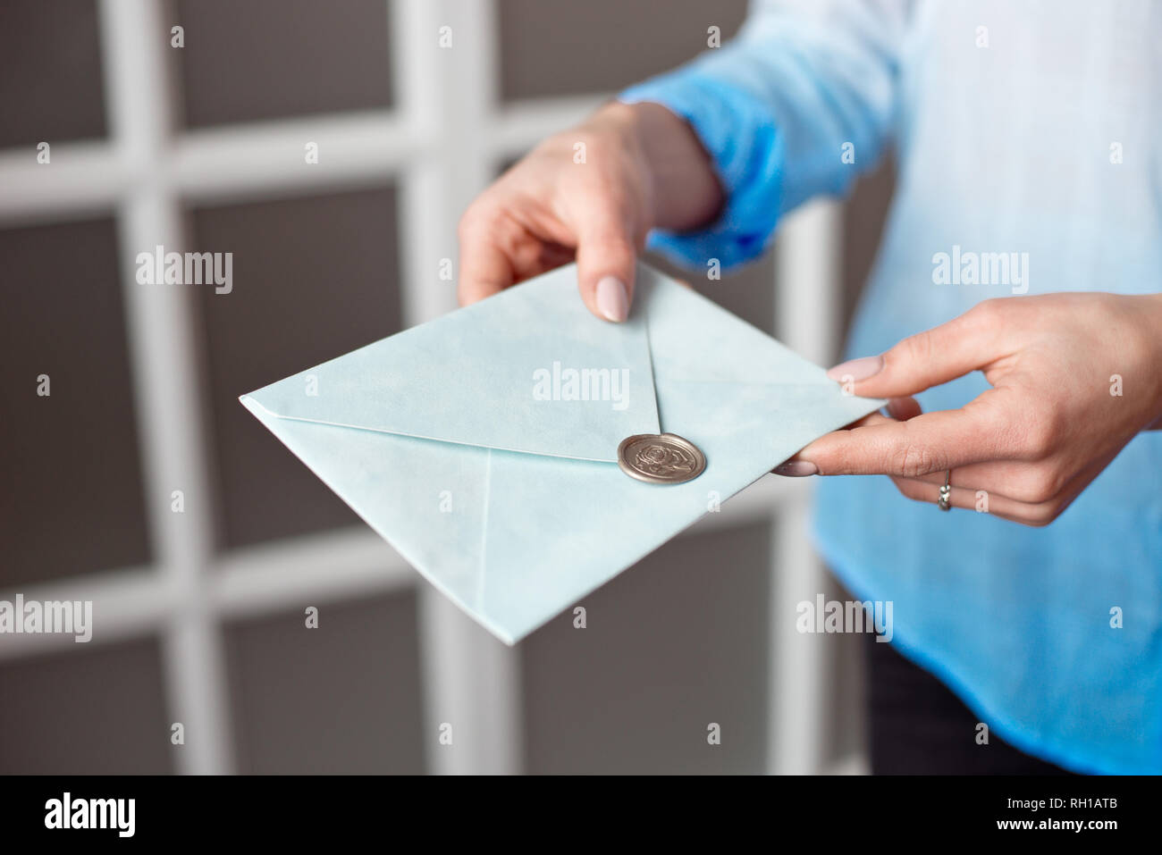 Close-up of a woman with a slim body holding a blue rectangular ...