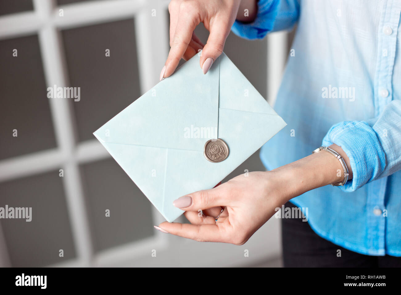 Close-up of a woman with a slim body holding a blue rectangular ...