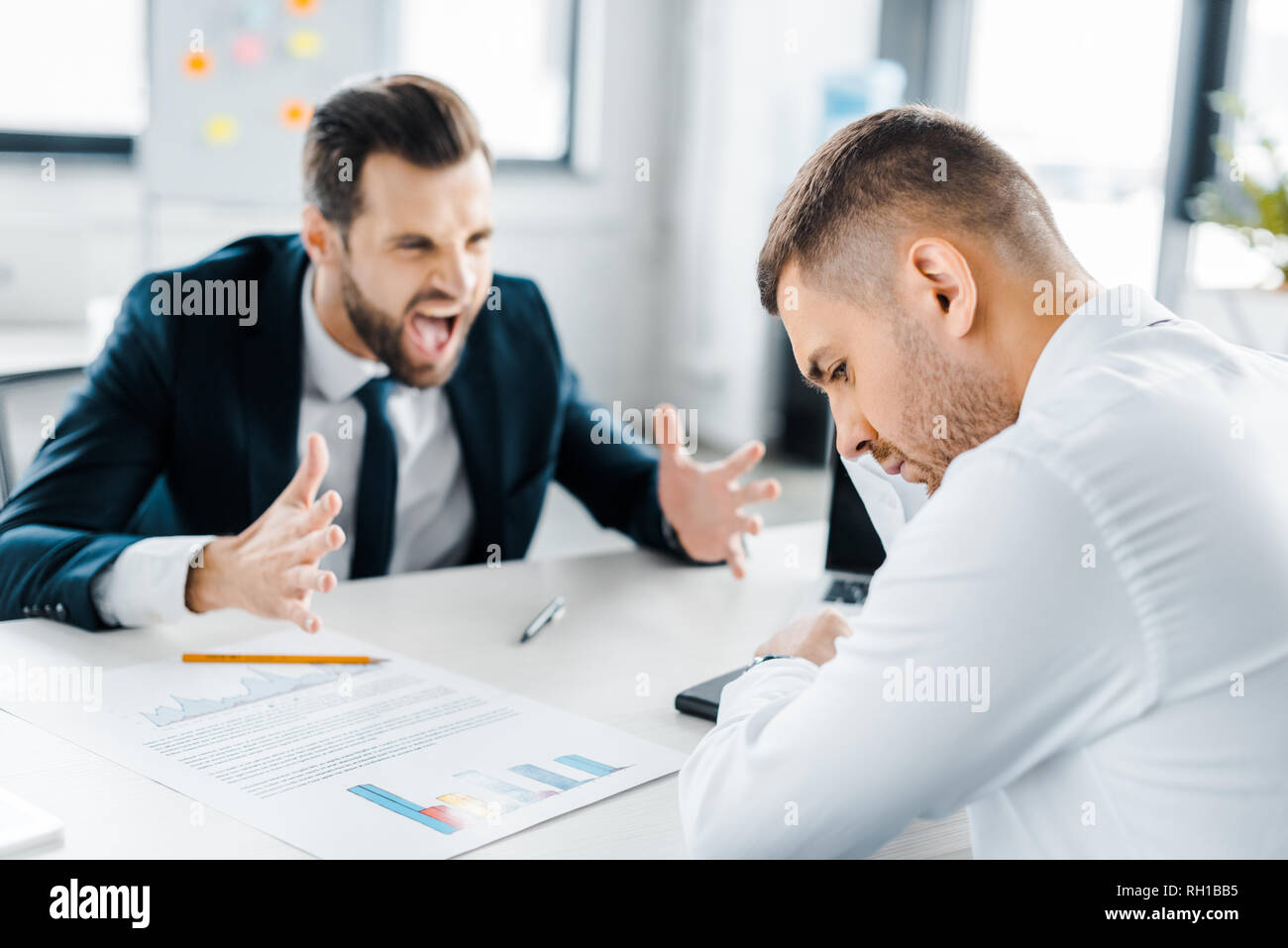 selective focus of upset man sitting near angry man in formal wear ...
